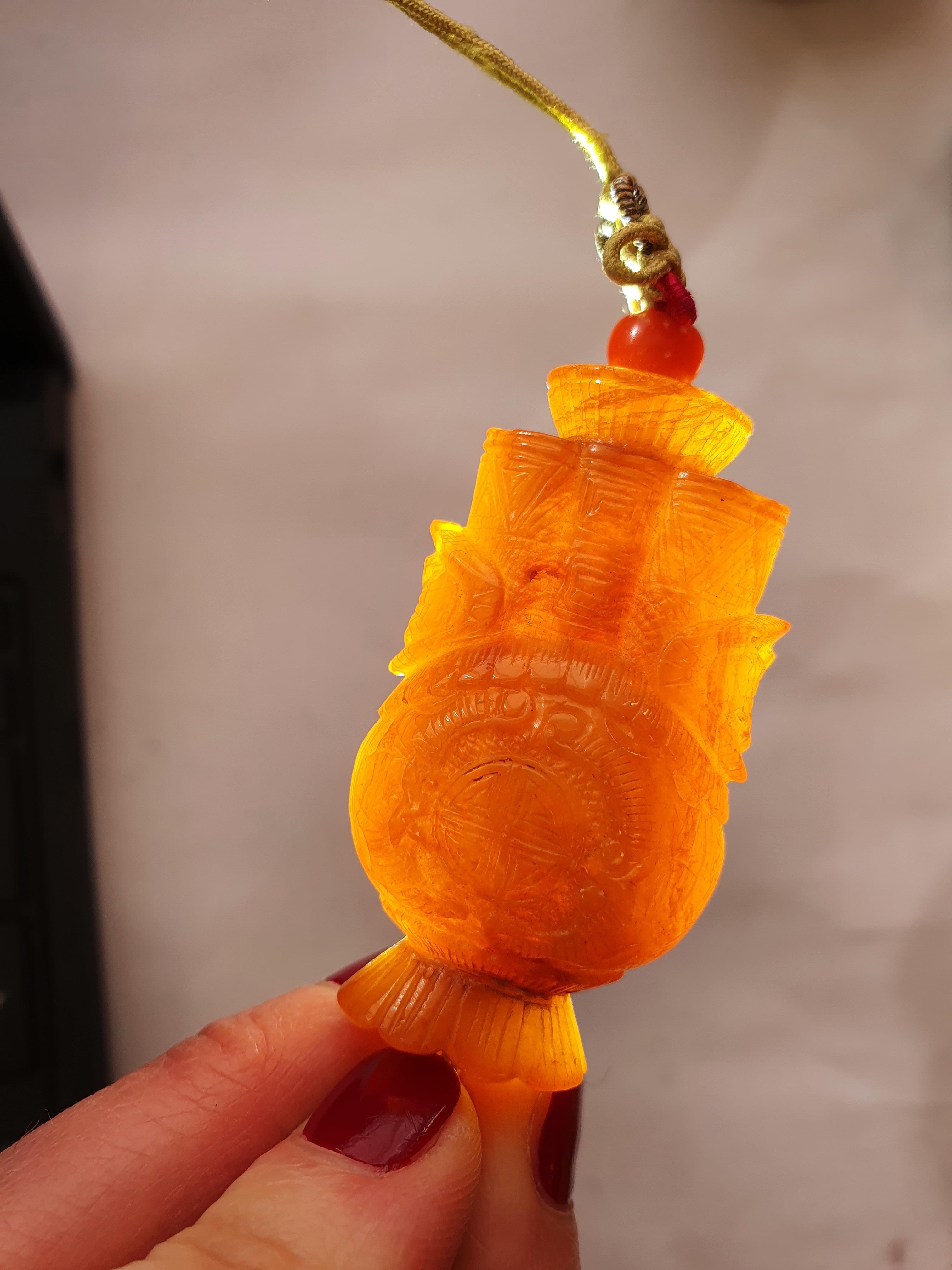 Lot 423 - A CHINESE AMBER 'VASE' PENDANT.