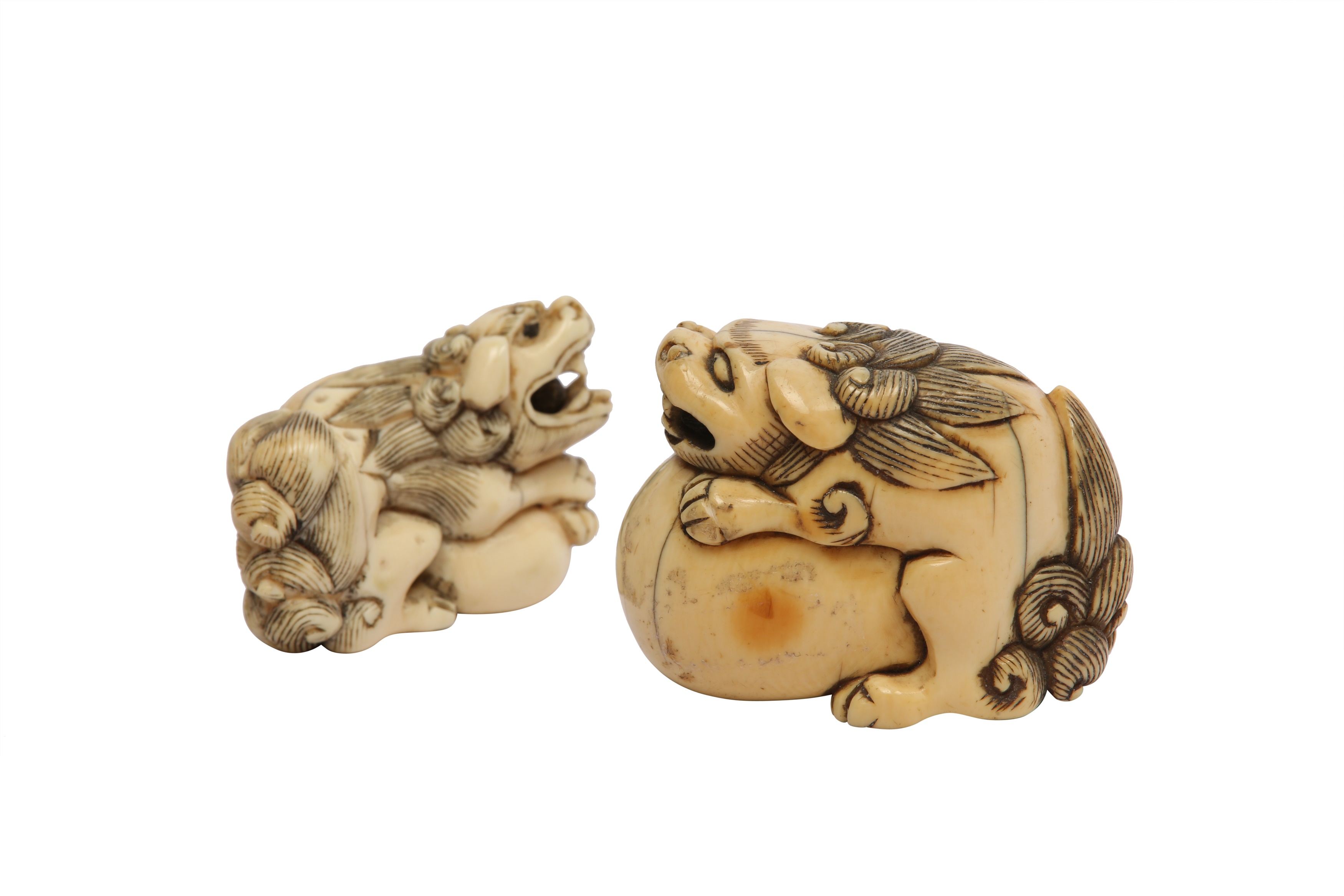 Lot 331 - TWO IVORY SHISHI DOG NETSUKE.