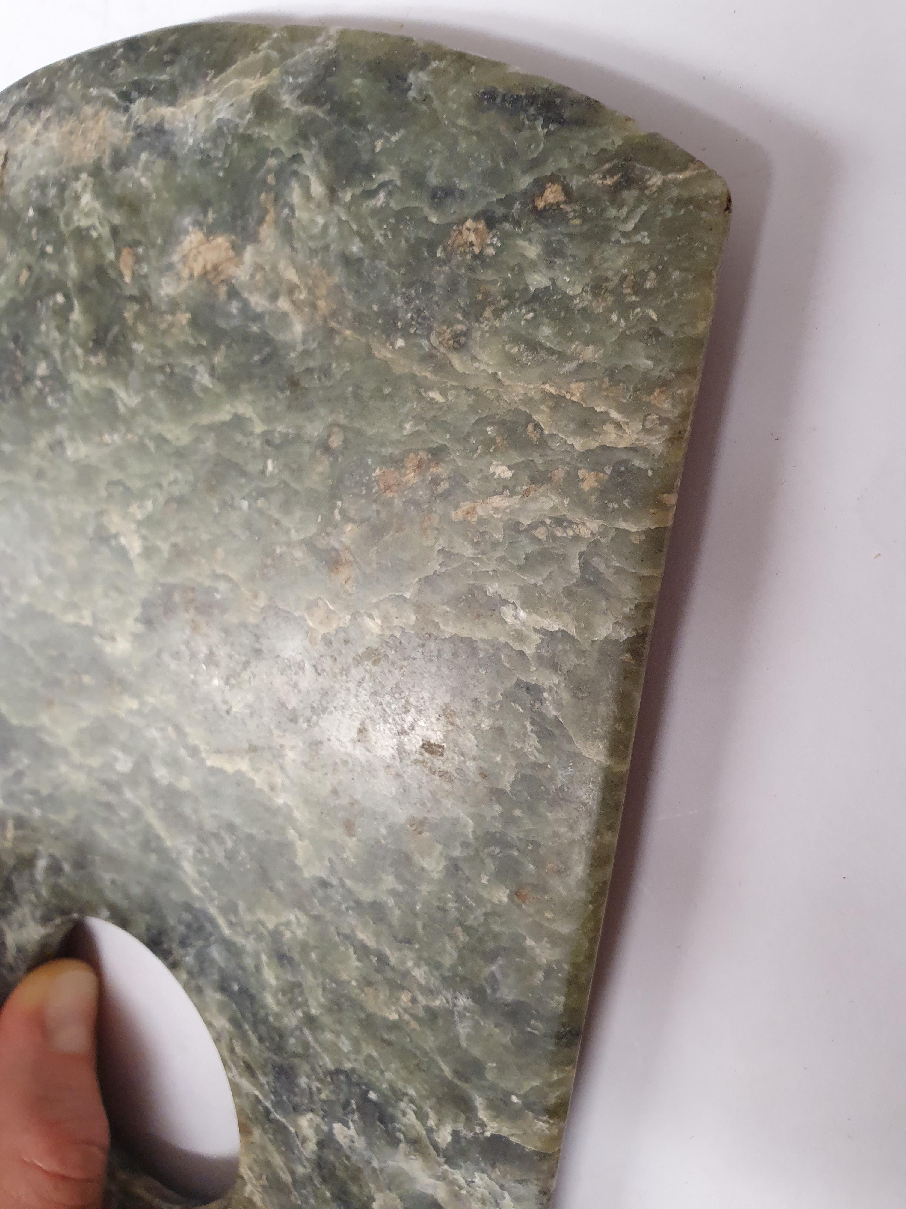 Lot 570 - A CHINESE CELADON JADE AXE HEAD.