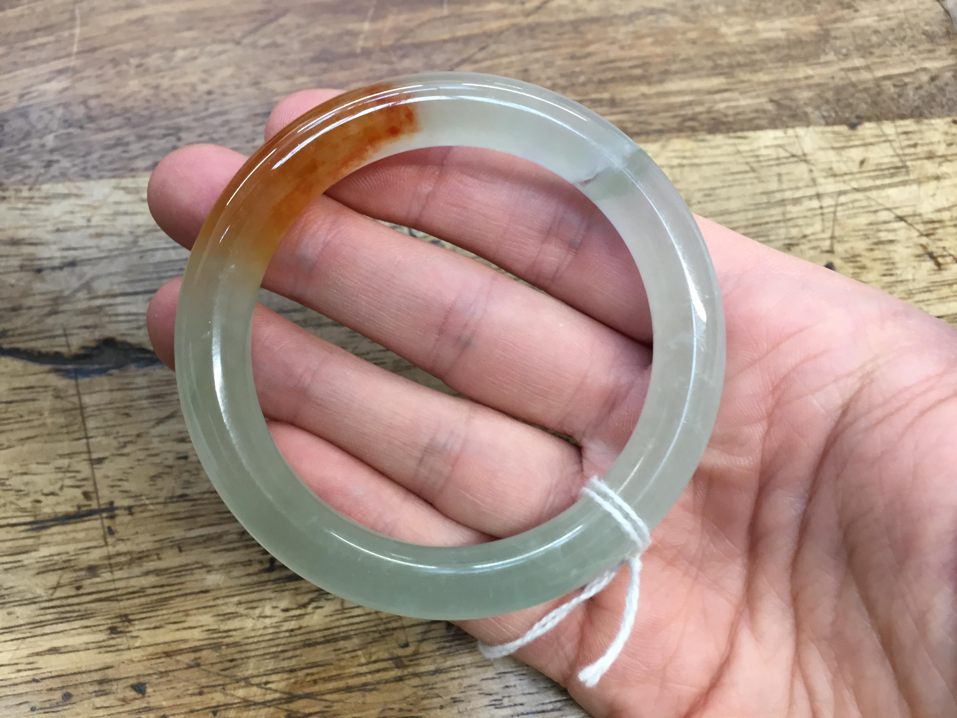 Lot 535 - A CHINESE PALE CELADON AND RUSSET JADE