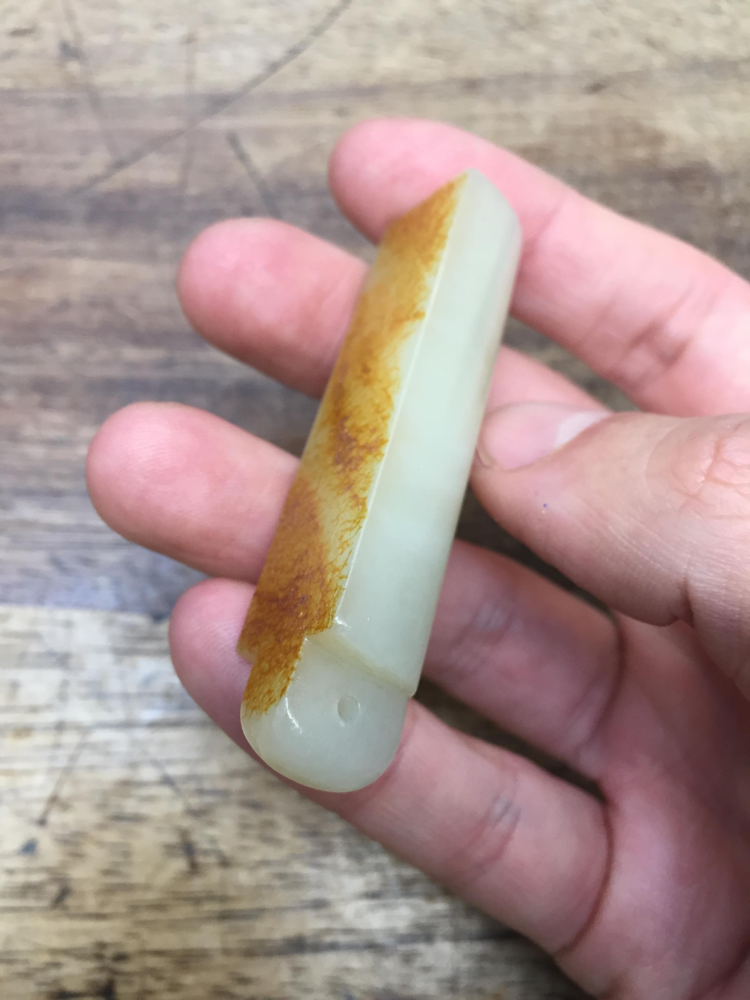 Lot 731 - A CHINESE CELADON AND RUSSET JADE PENDANT