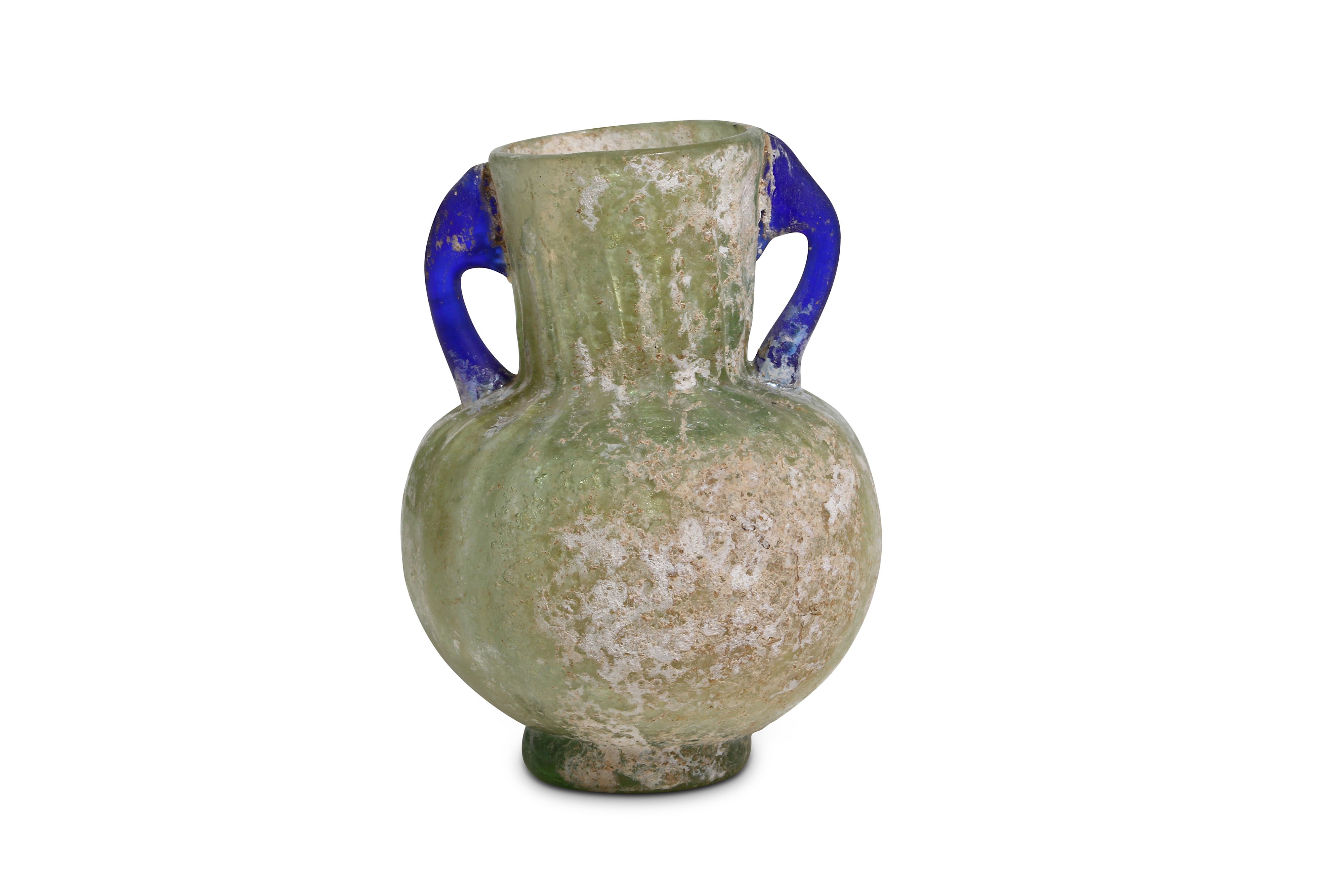 Lot 135 - A ROMAN GREEN GLASS MOULD-BLOWN FLASK Circa